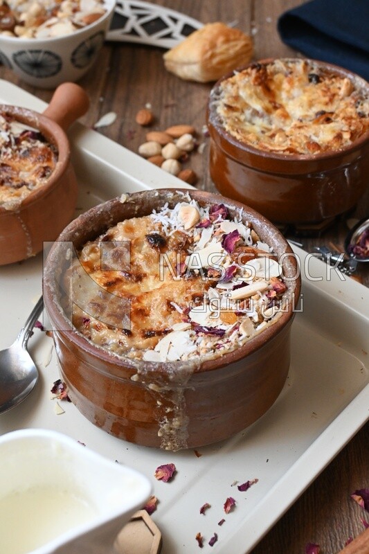 Plate of om ali with nuts on it next to cinnamon