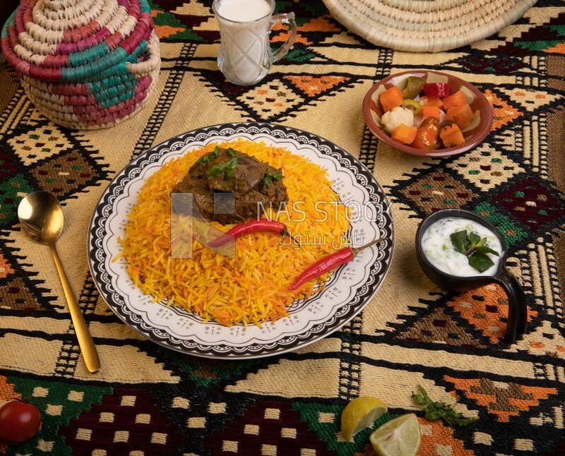 Wooden plate of delicious biryani rice with meat, traditional Arabic ...