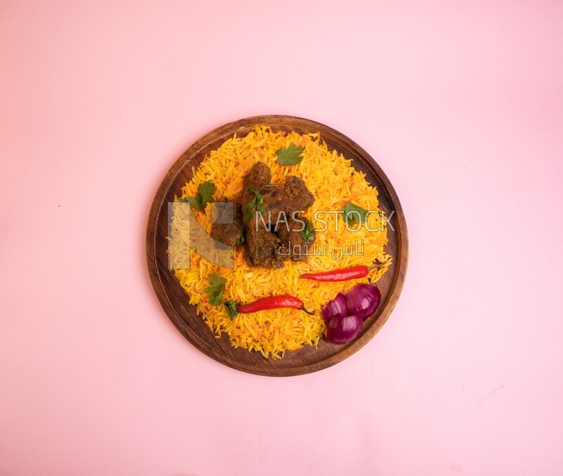 Wooden plate of delicious biryani rice with meat, traditional Arabic ...
