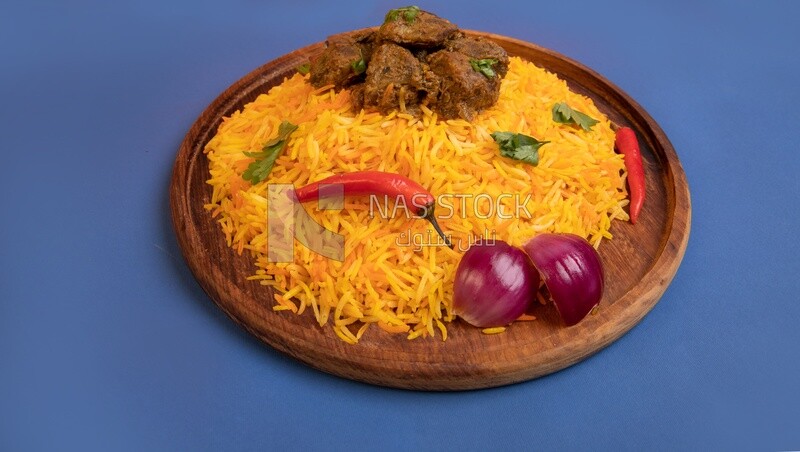 Wooden plate of delicious biryani rice with meat, traditional Arabic ...