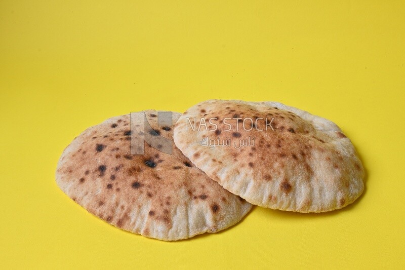Arabic white bread, freshly baked, placed on a yellow background
