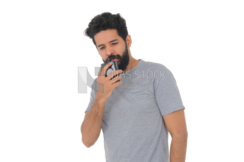 Saudi man holding a perfume bottle, applying perfume, selfcare, skin ...
