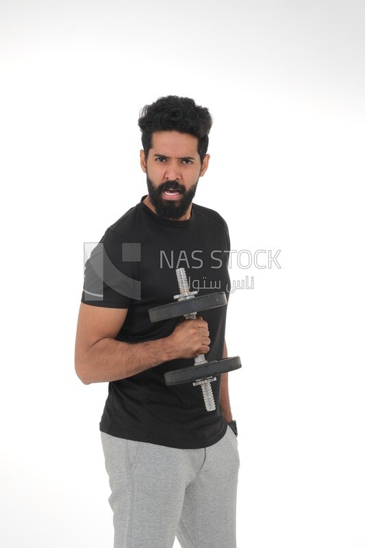 Saudi man Wearing sports clothes, exercising with dumbbells ...