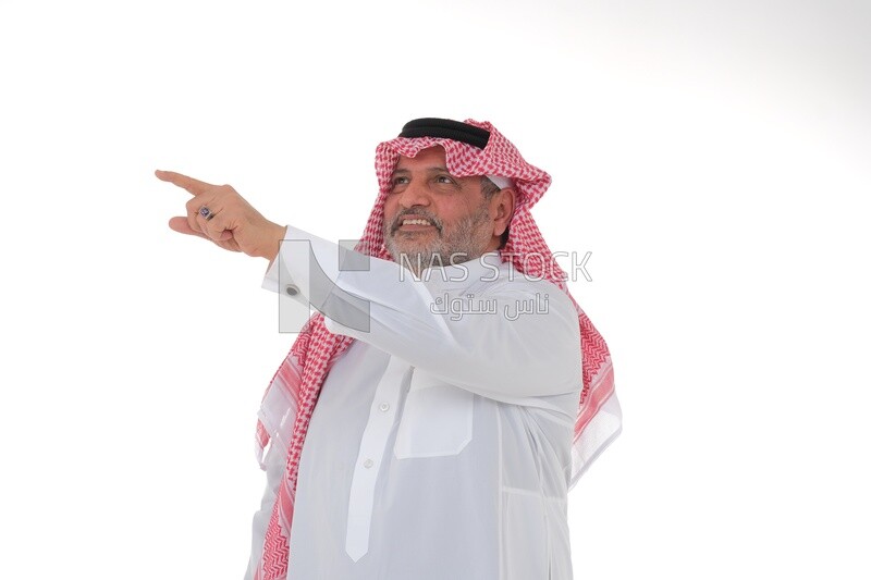 close-up of a Saudi man in traditional Saudi dress pointing away, side ...