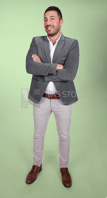 Portrait of a handsome man standing wearing formal wear with crossed ...