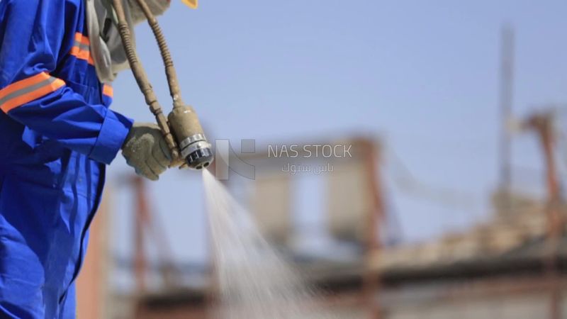 Worker applies material insulating the building, Isolation work